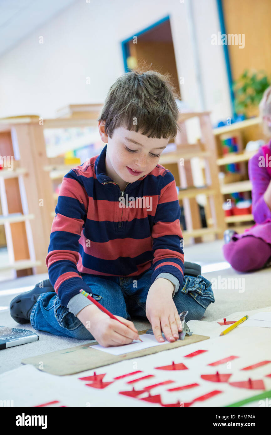 Caucasian boy drawing in classroom Stock Photo - Alamy