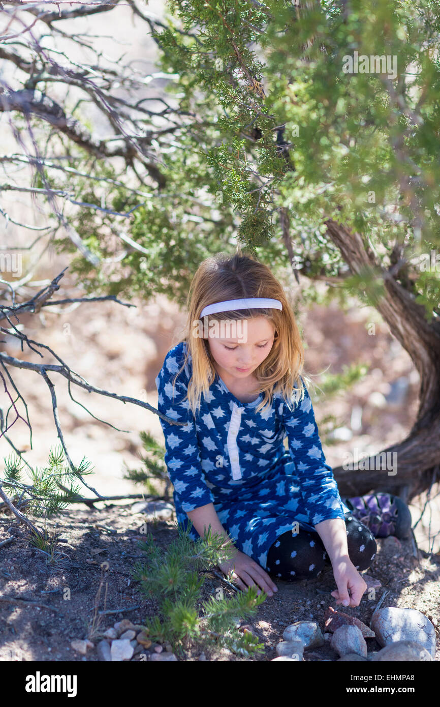 Caucasian girl sitting under tree Stock Photo - Alamy