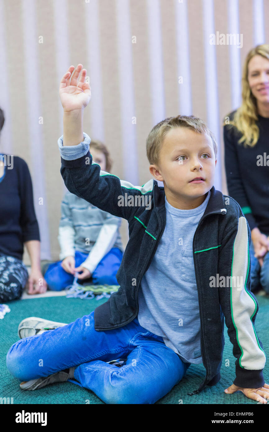 Boy raising hand in classroom Stock Photo - Alamy