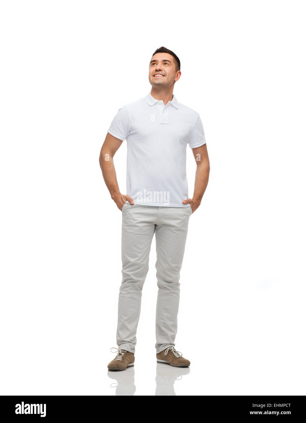 smiling man with hands in pockets looking up Stock Photo - Alamy