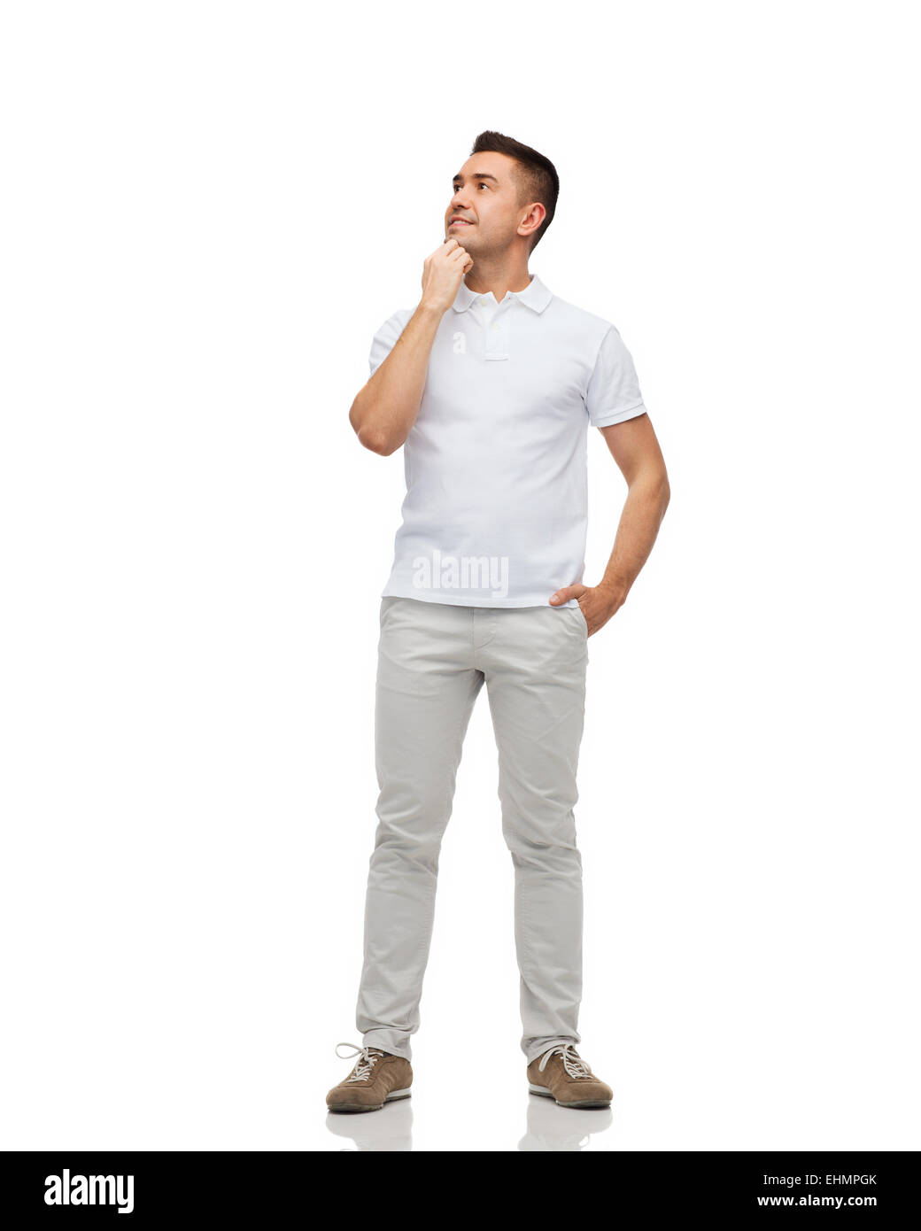 smiling man with hands in pockets looking up Stock Photo - Alamy