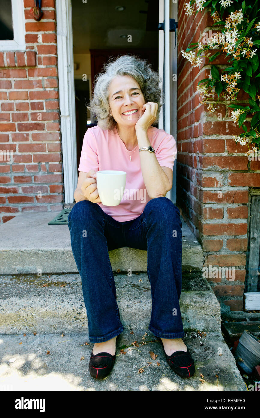 Woman sitting on stoop drinking hi-res stock photography and images - Alamy