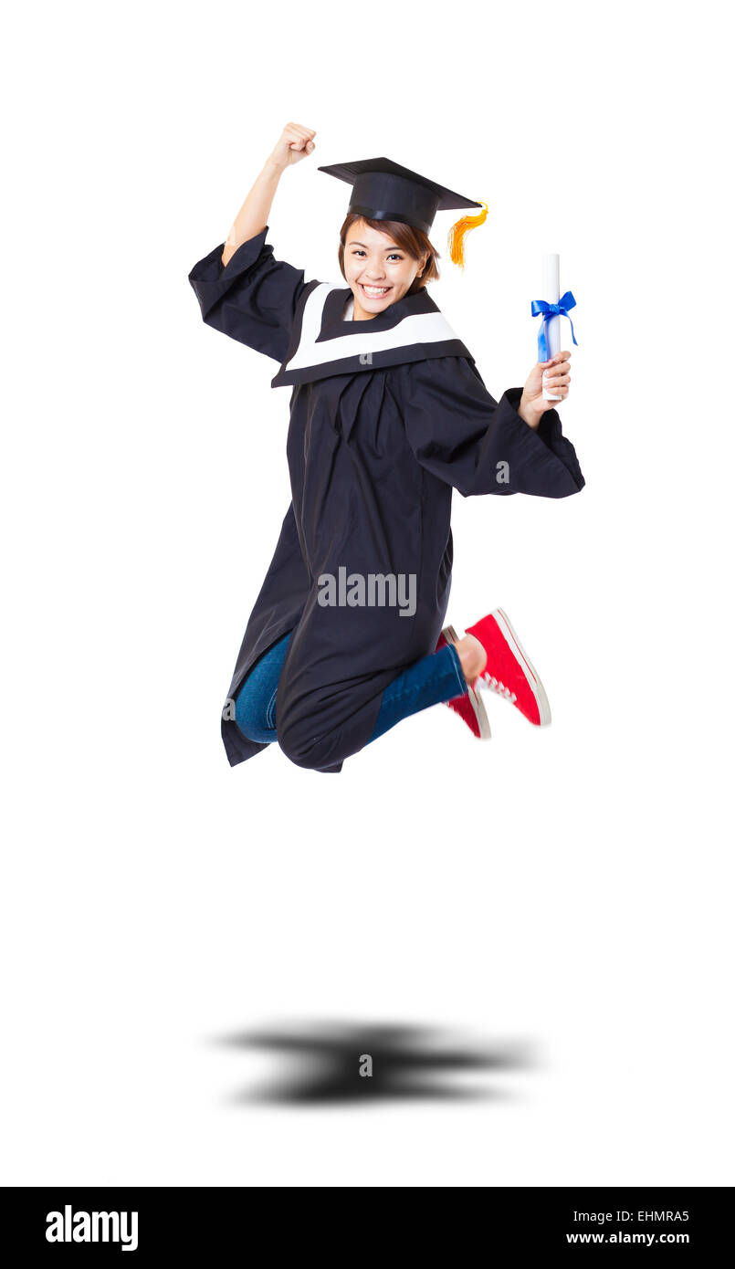 Happy female student in graduate robe jumping against white background ...