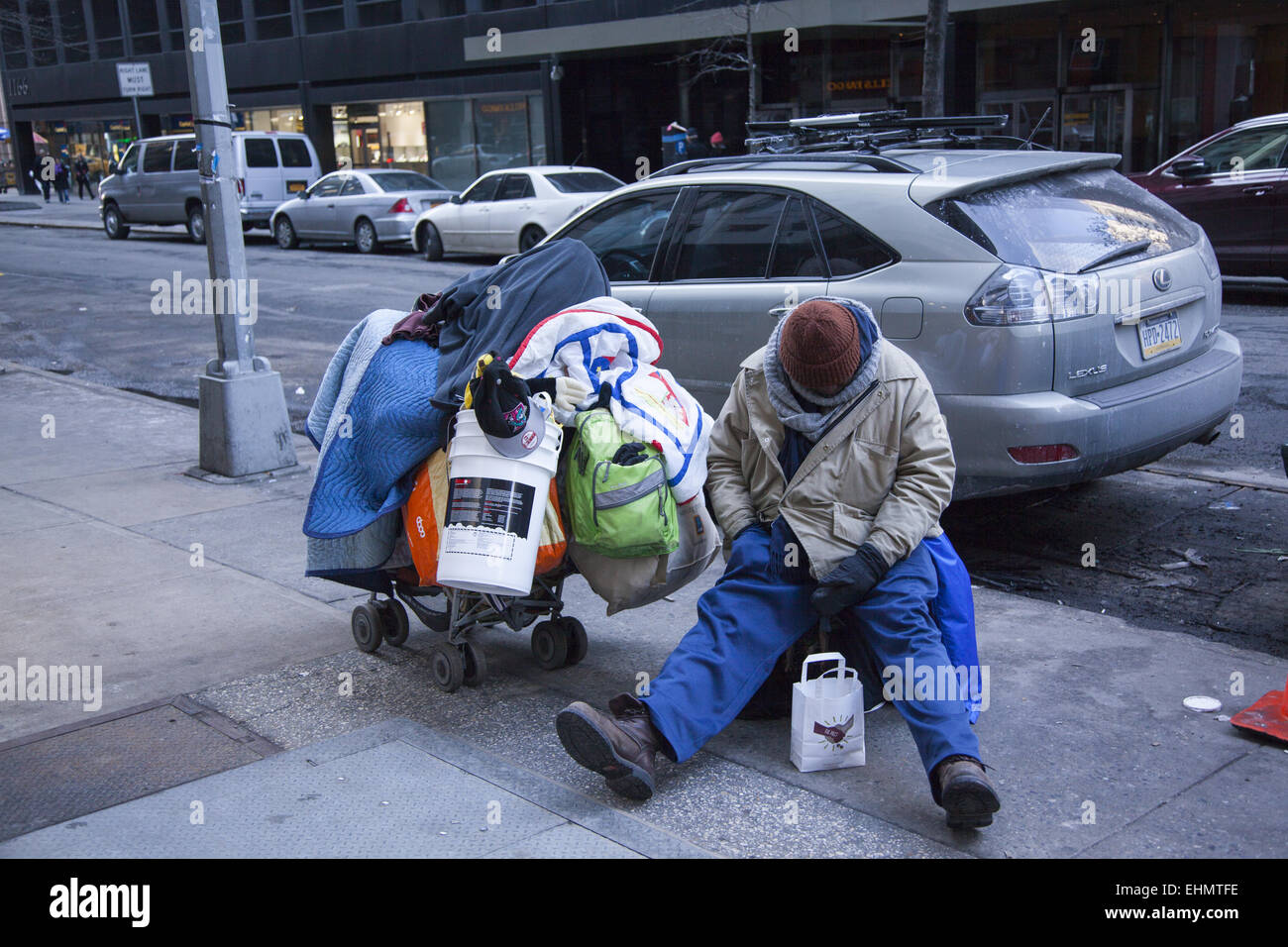 Homeless man with his worldly possessions asking for change outside a ...
