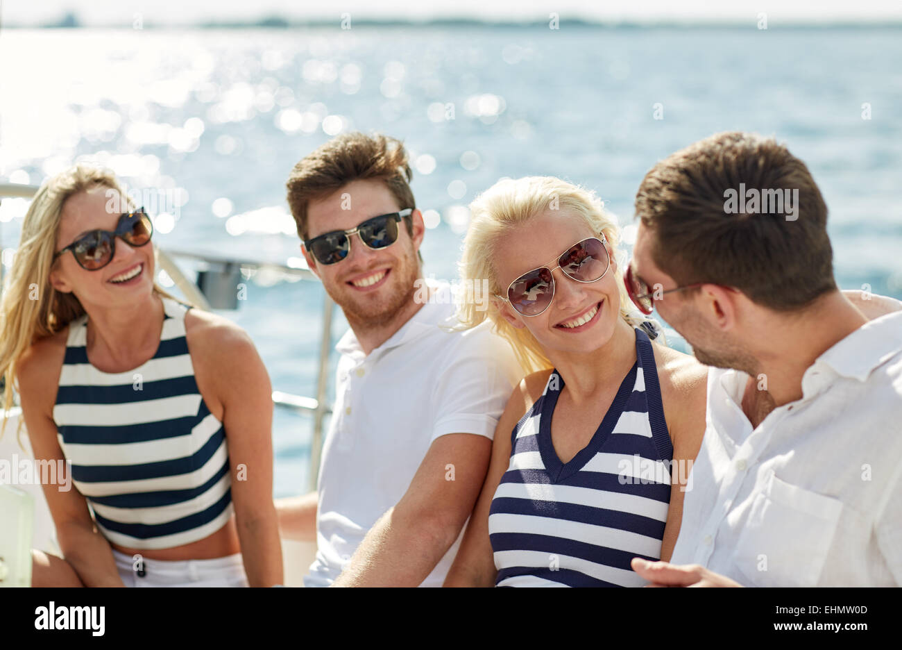smiling friends sitting on yacht deck Stock Photo - Alamy