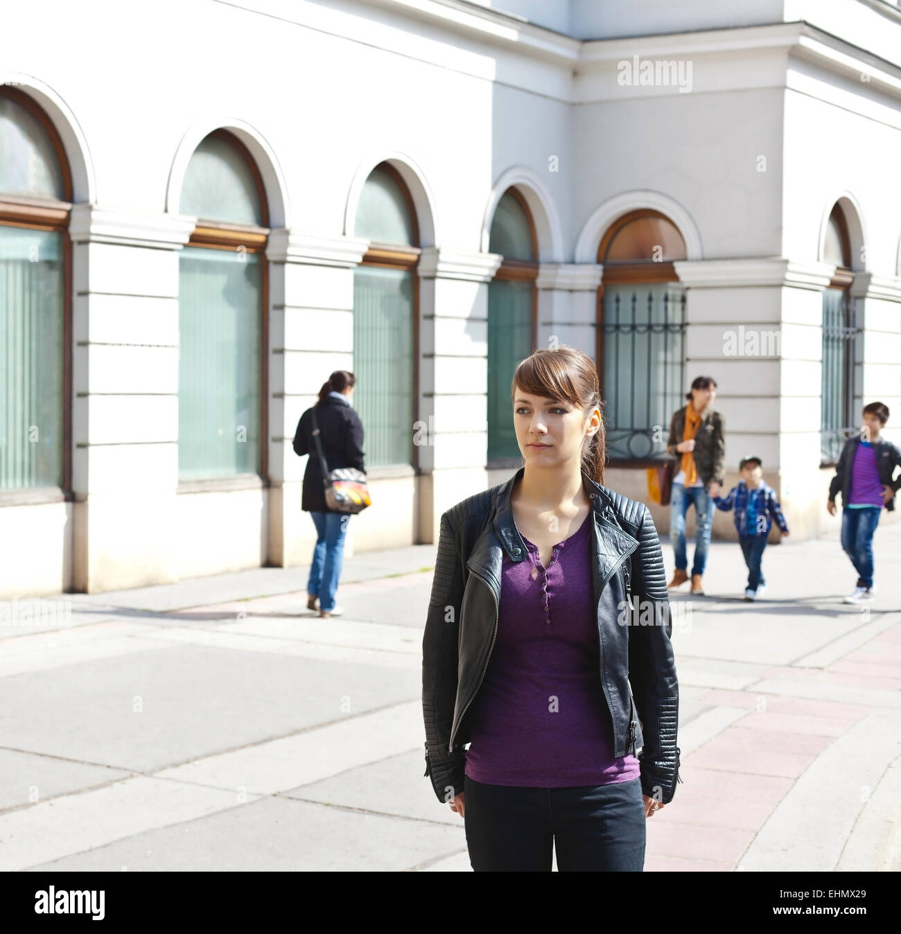Thoughtful urban girl standing out from the crowd at a city street ...