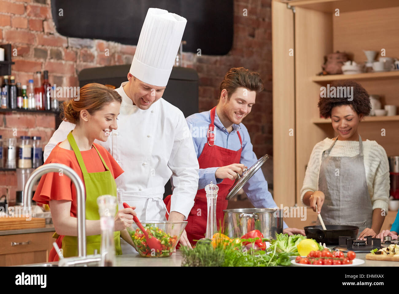 happy friends and chef cook cooking in kitchen Stock Photo - Alamy