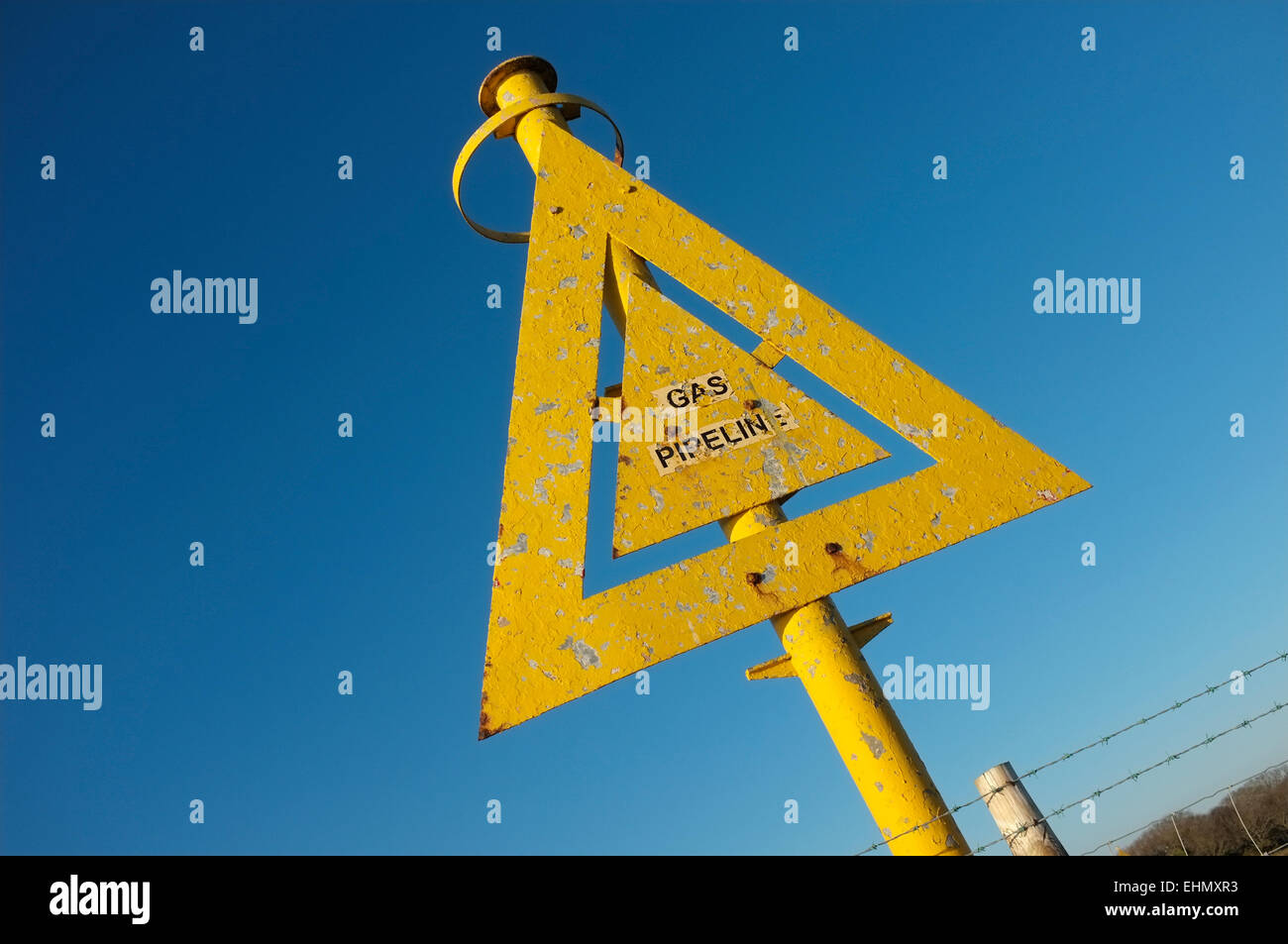 Gas pipeline warning triangle against blue sky Stock Photo - Alamy