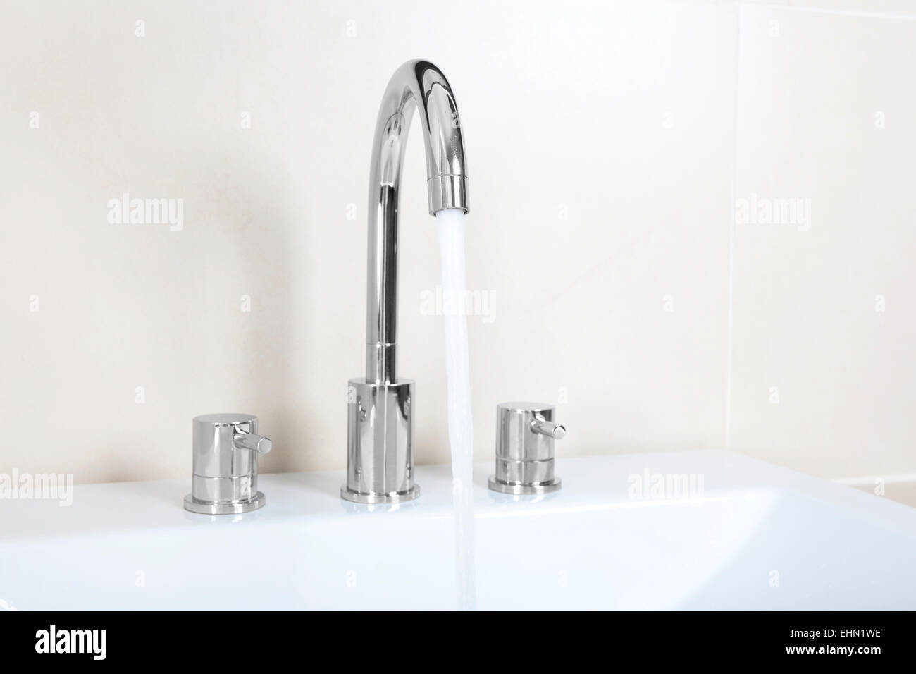 a modern washstand with shiny faucet from the water runs Stock Photo ...
