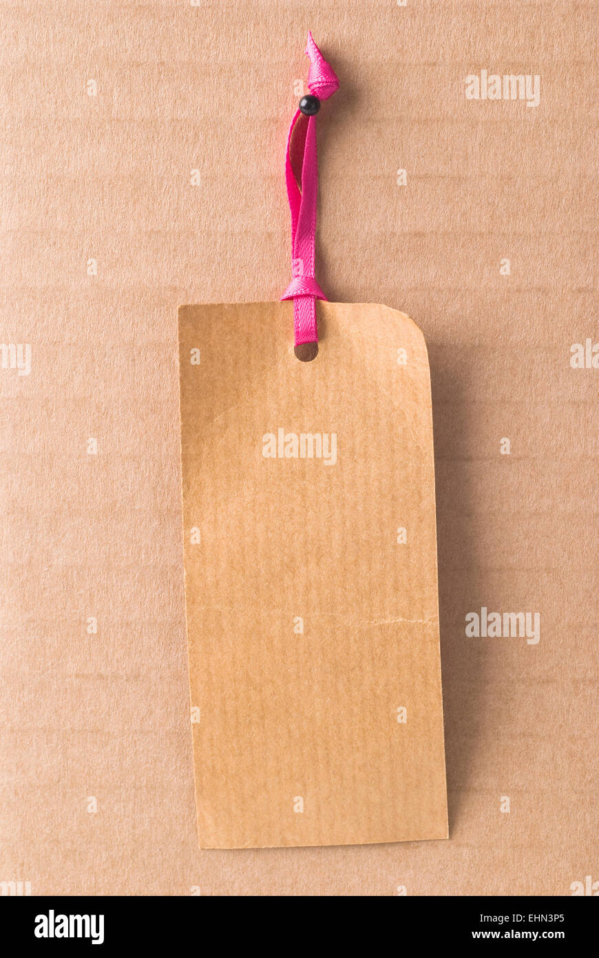Paper tag with pink satin string on cardboard Stock Photo - Alamy