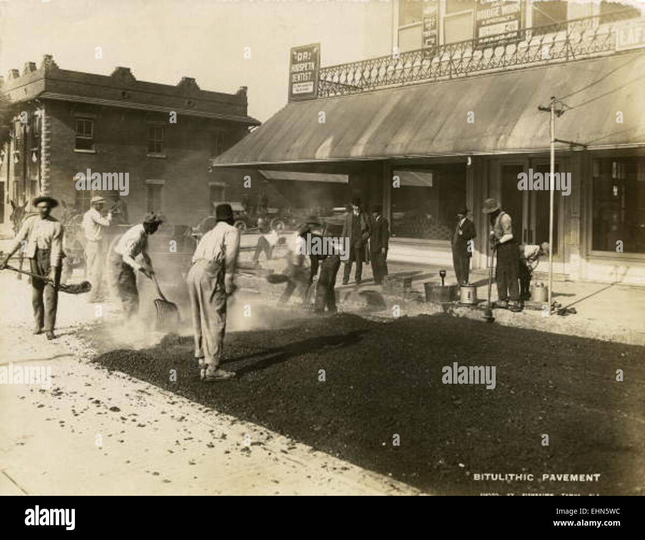 The image depicts workers laying bitulithic pavement in Tampa, a ...