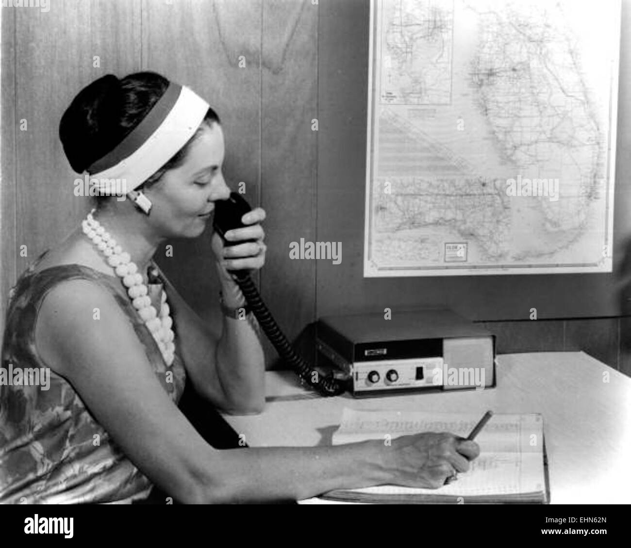 A photograph capturing a woman using a two-way radio in Miami ...