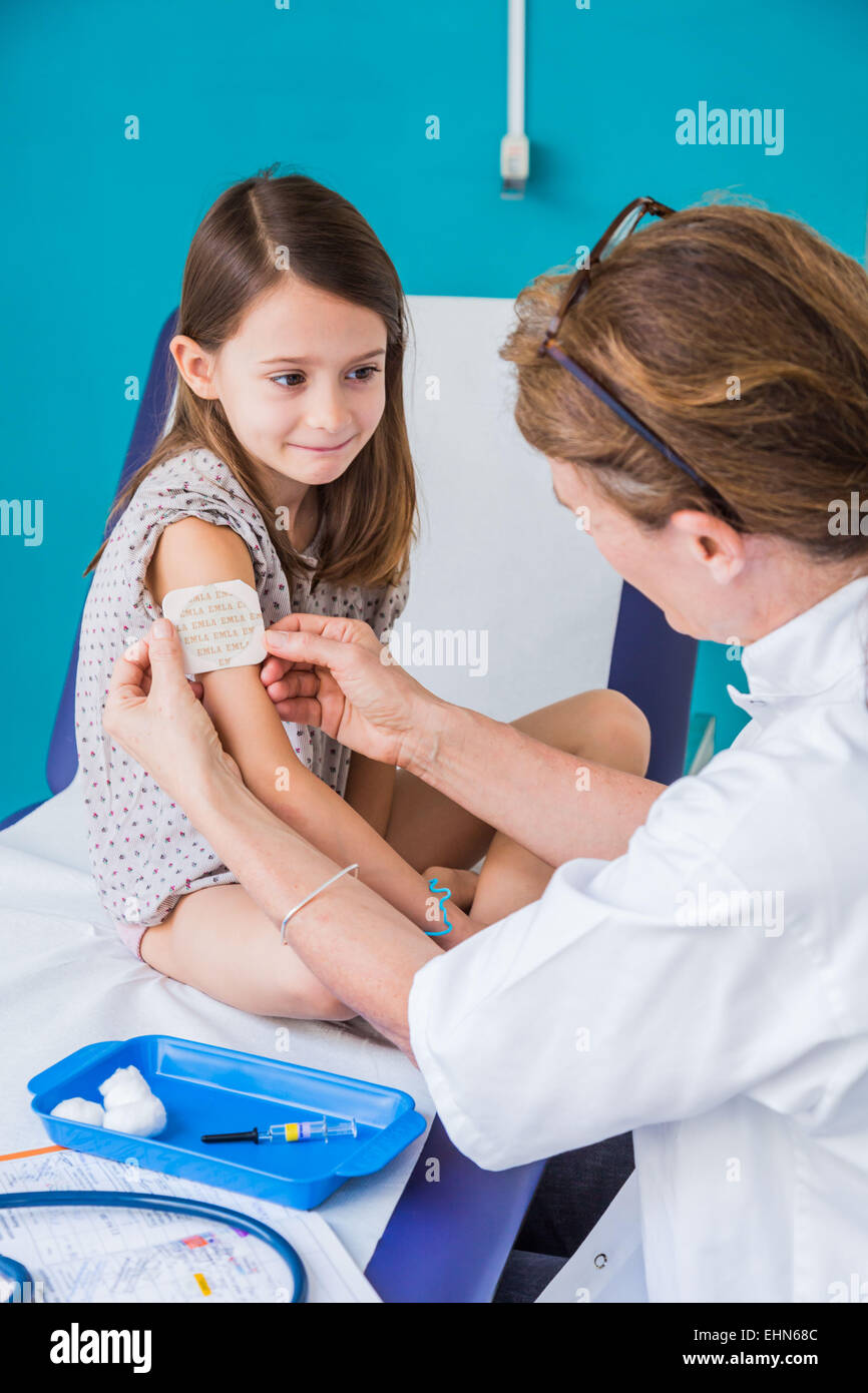 Doctor using a path EMLA (EMLAPATCH) skin adhesive bandage used to numb ...