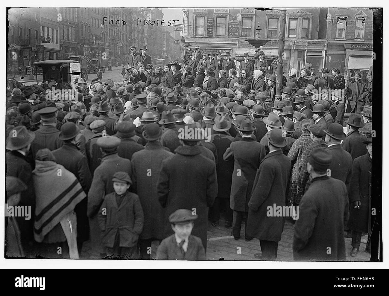 This historical photograph captures a food protest, where people ...