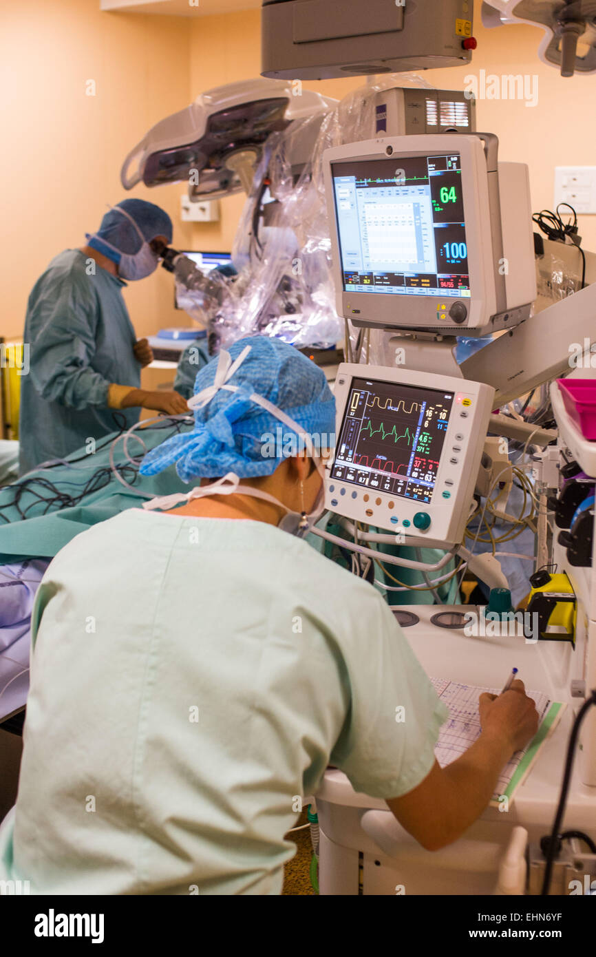 Surgeon performing cochlear implant surgery, an operation involving the ...