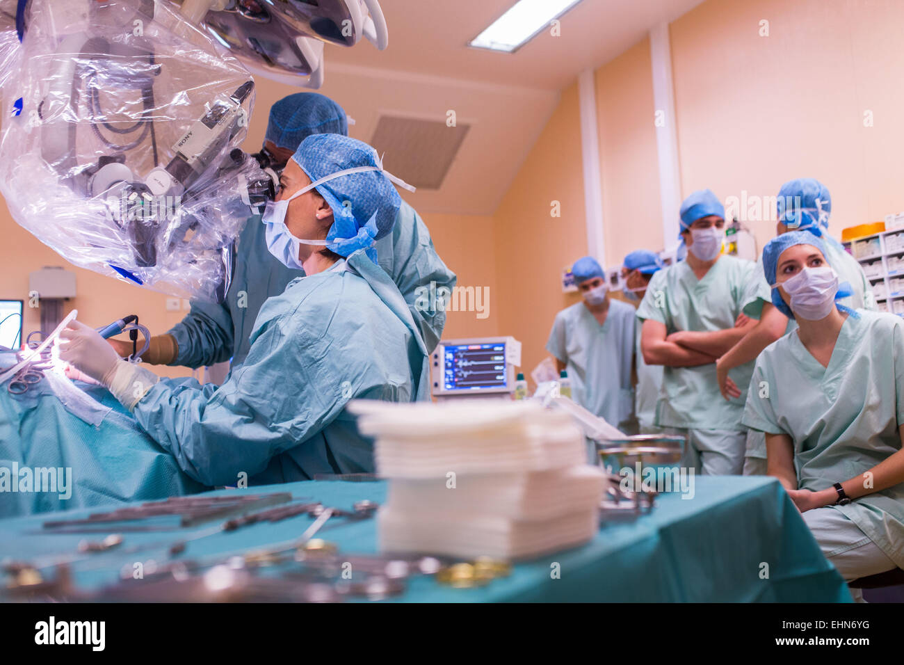 Surgeon performing cochlear implant surgery, an operation involving the ...