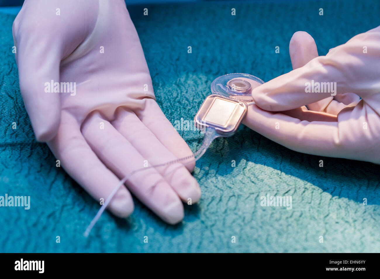 Surgeon performing cochlear implant surgery, an operation involving the ...