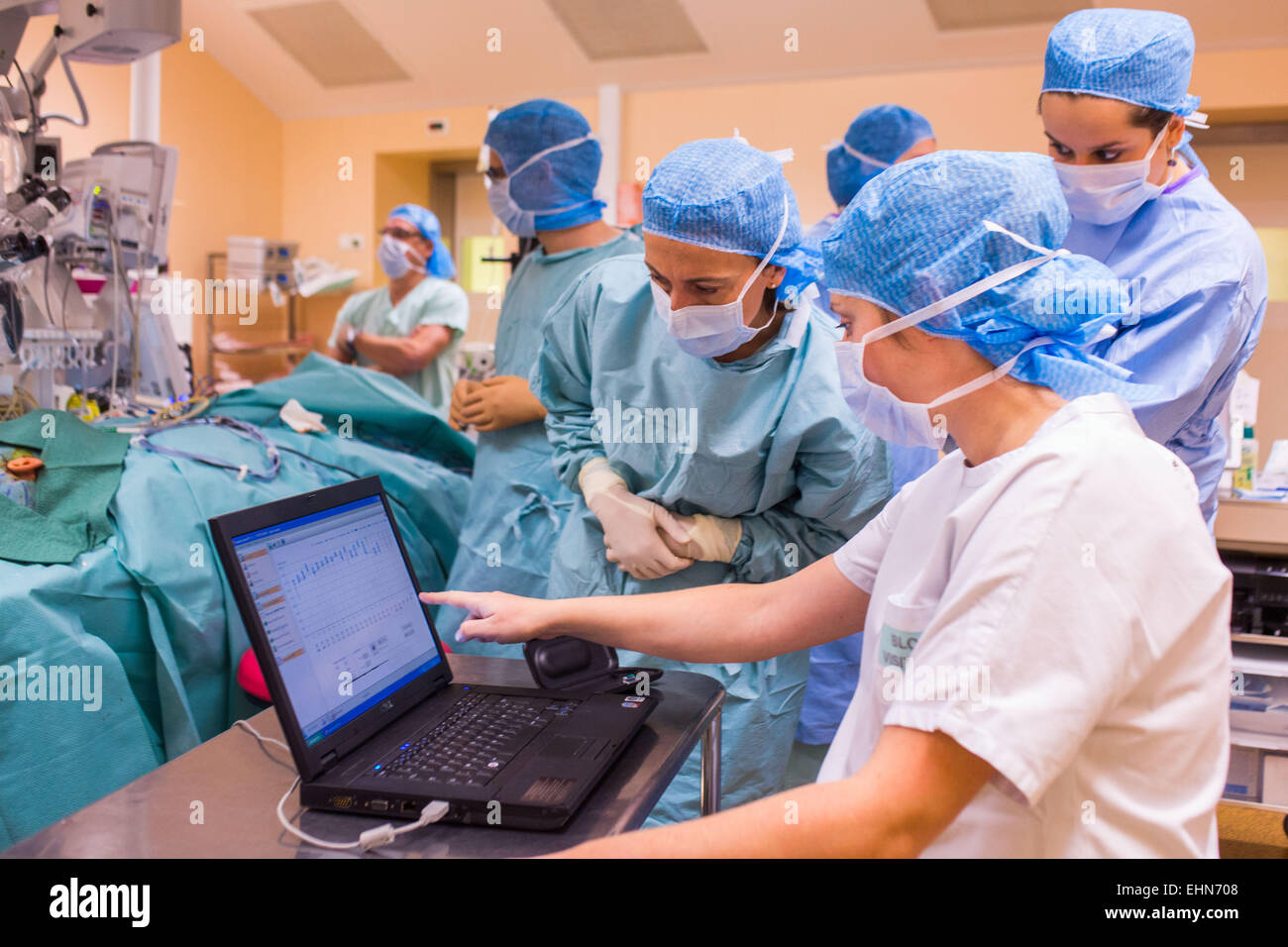 Surgeon performing cochlear implant surgery, an operation involving the ...