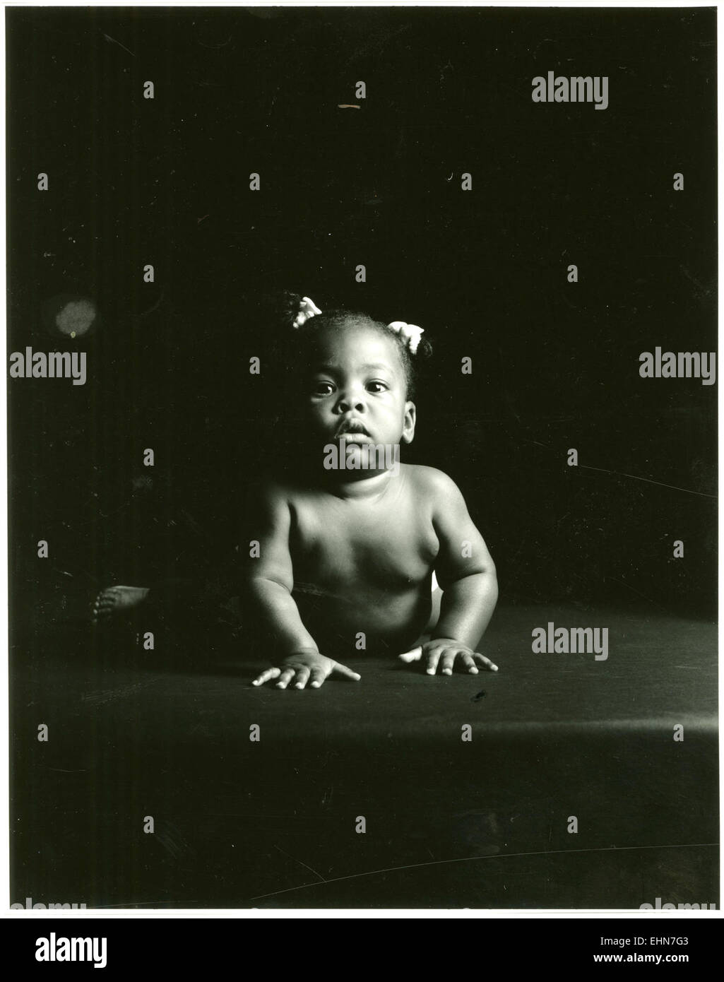 This image portrays a baby in a simple, yet heartwarming moment ...