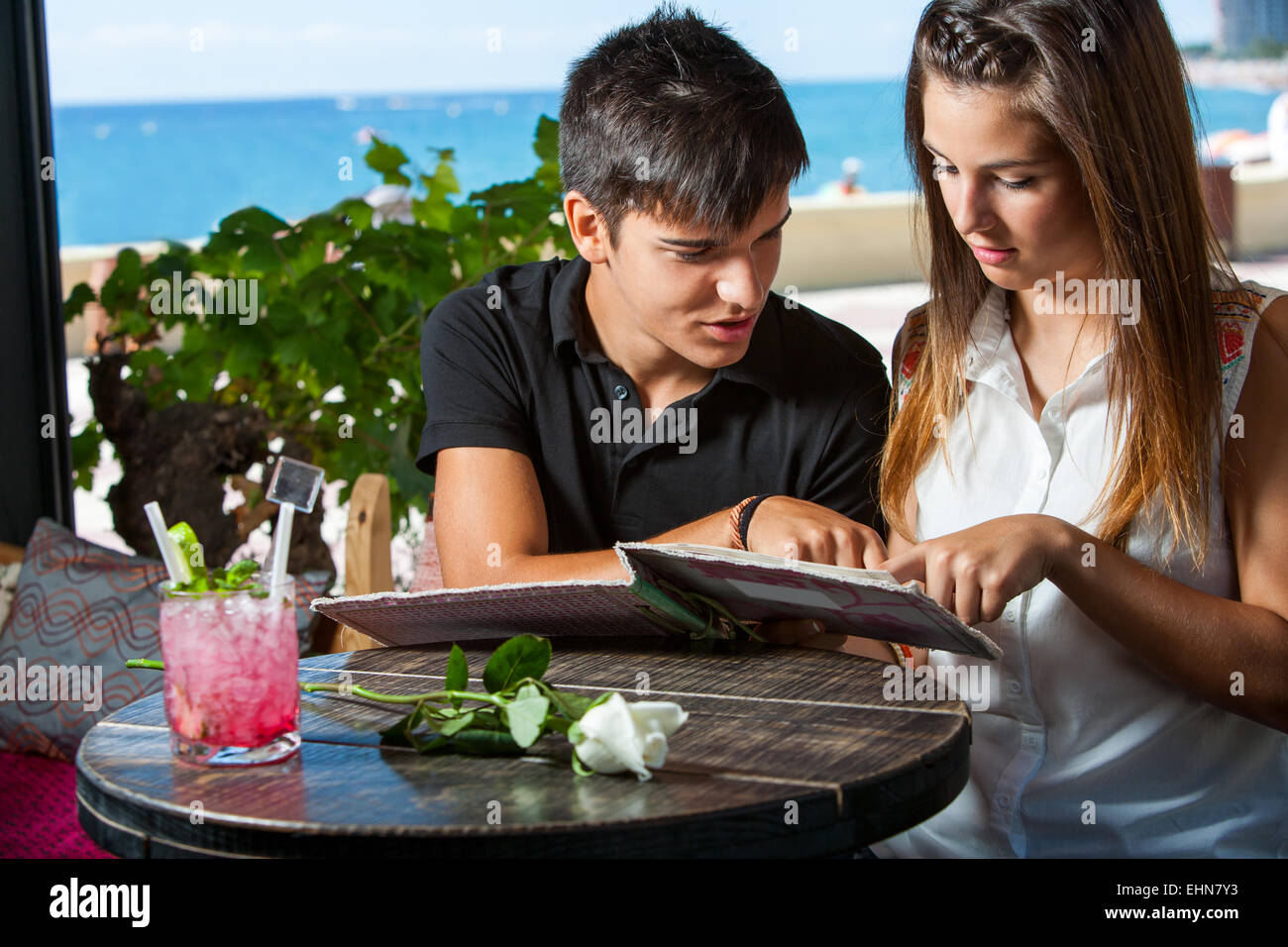 close up portrait of cute teen couple looking at menu in restaurant ...