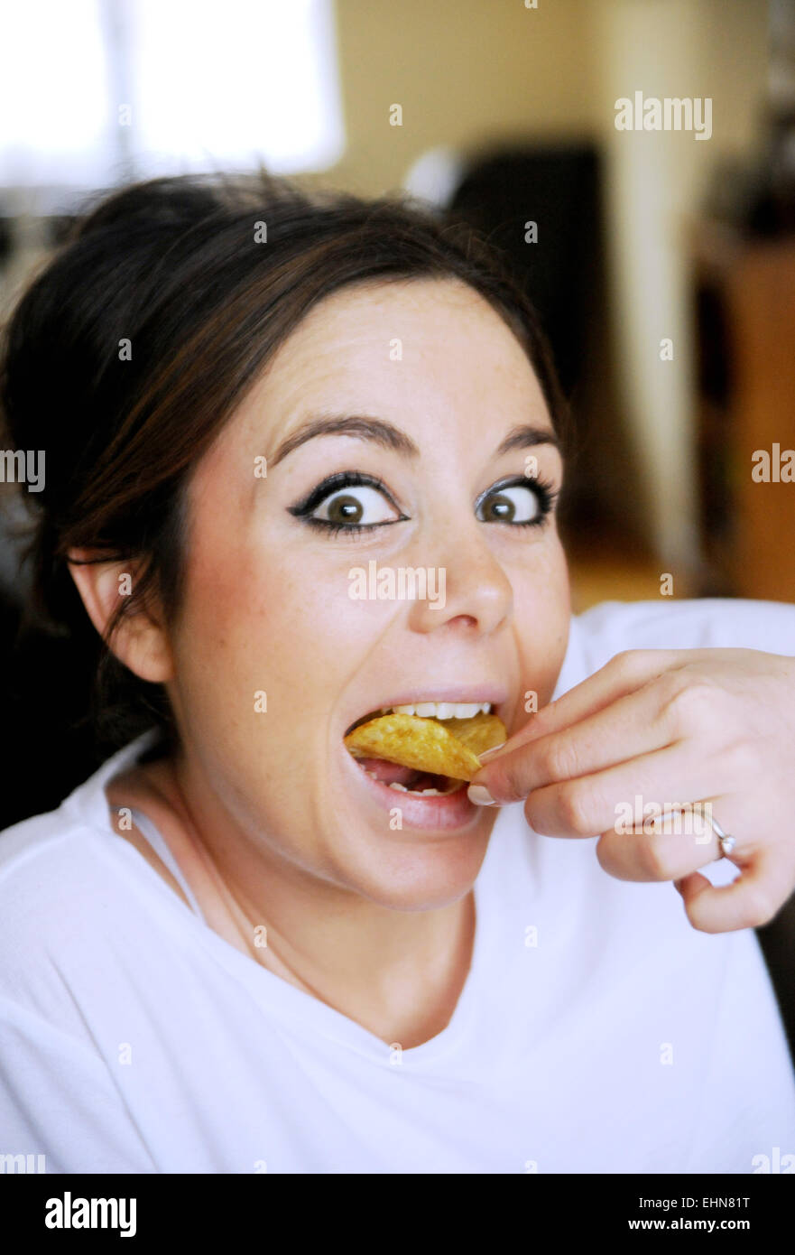 Young woman eating potato crisps Stock Photo - Alamy