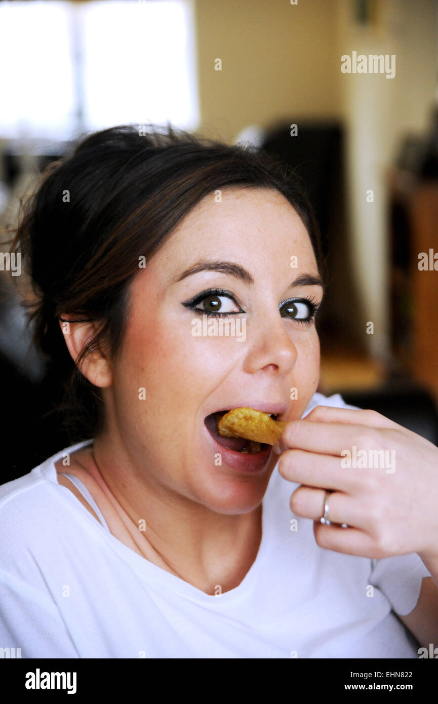 Young woman eating potato crisps Stock Photo - Alamy