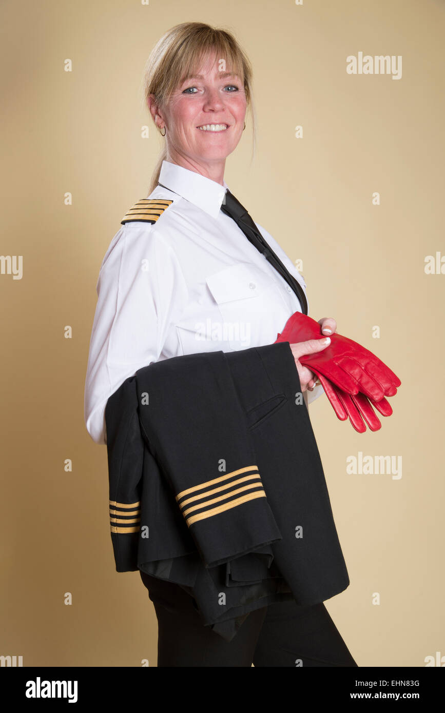Attractive female airline Captain standing in uniform holding jacket ...