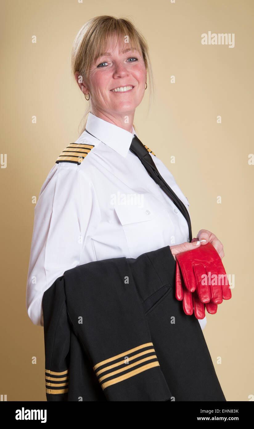 Attractive female airline Captain standing in uniform holding jacket ...