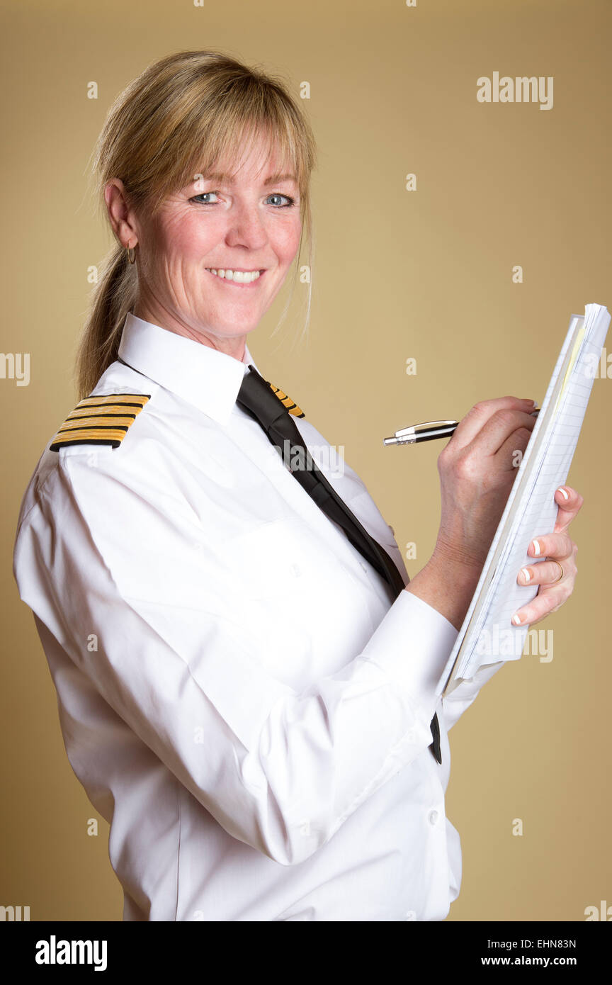 Female airline pilot in uniform and holding a pen Stock Photo - Alamy