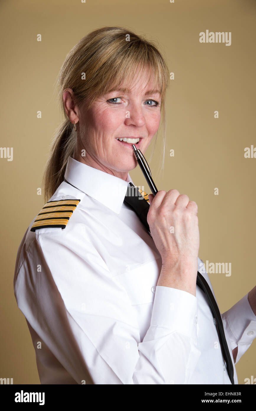Female airline pilot in uniform and holding a pen Stock Photo - Alamy