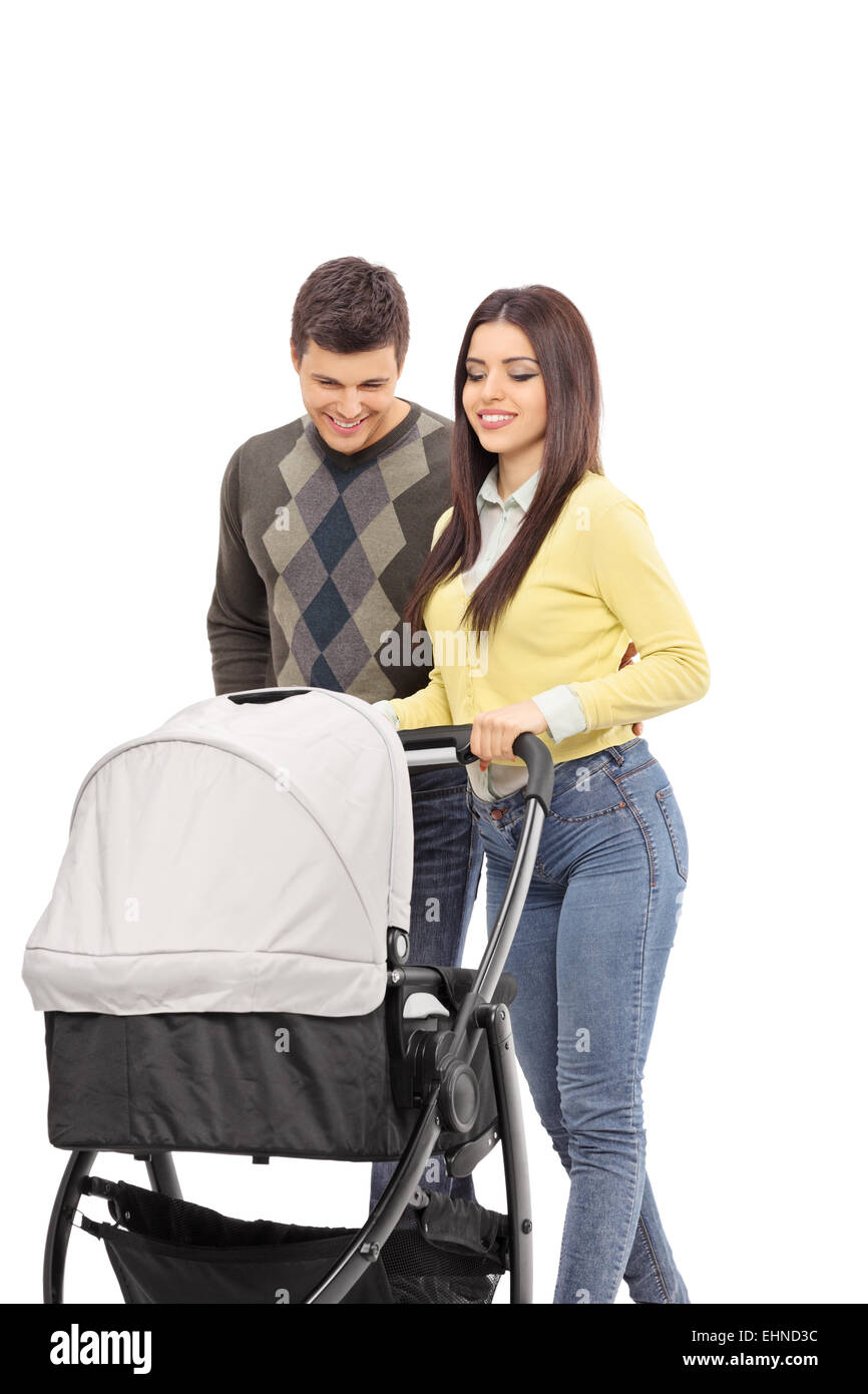 Vertical shot of young parents pushing a baby stroller isolated on ...