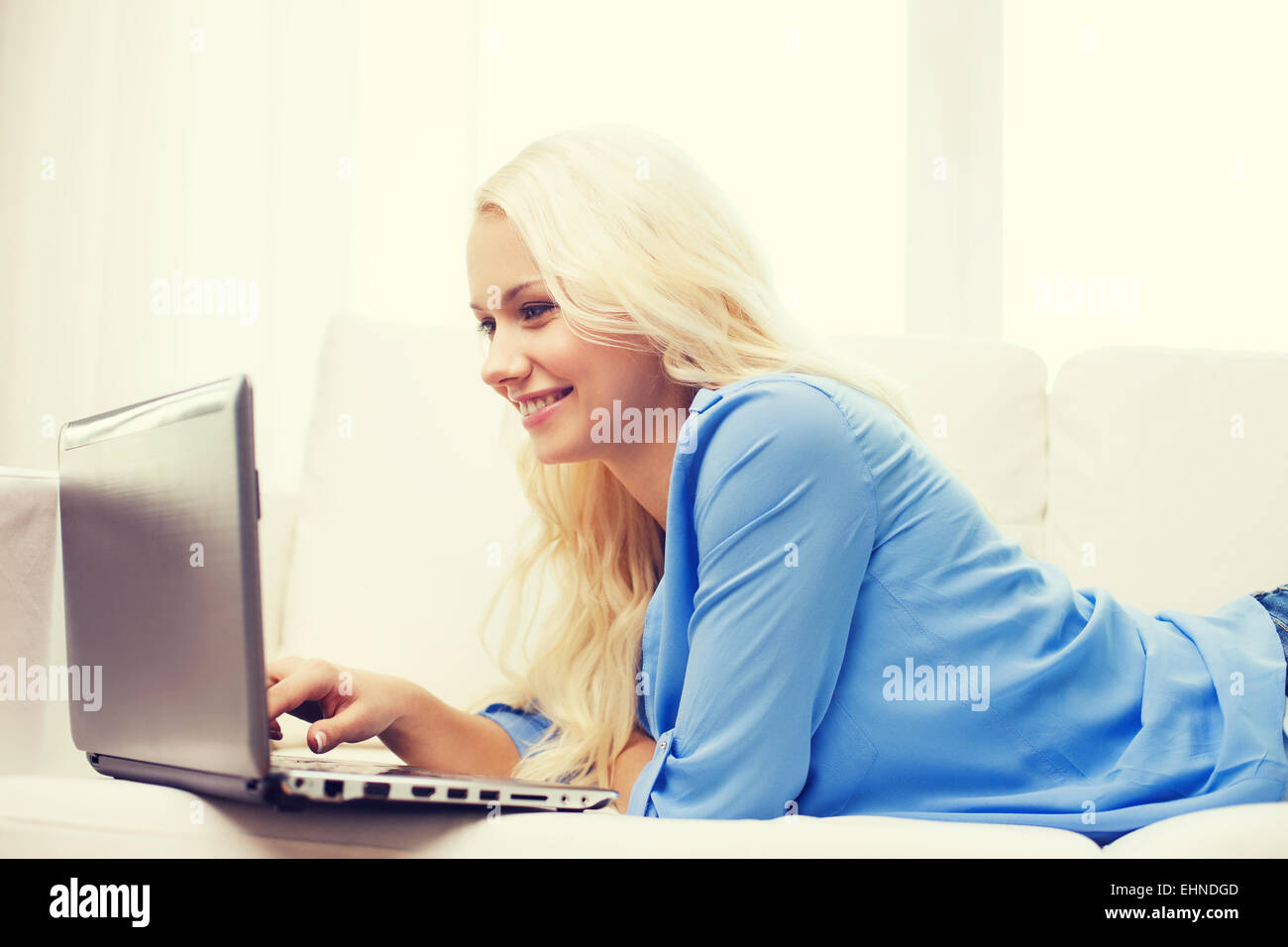 smiling woman with laptop computer at home Stock Photo - Alamy