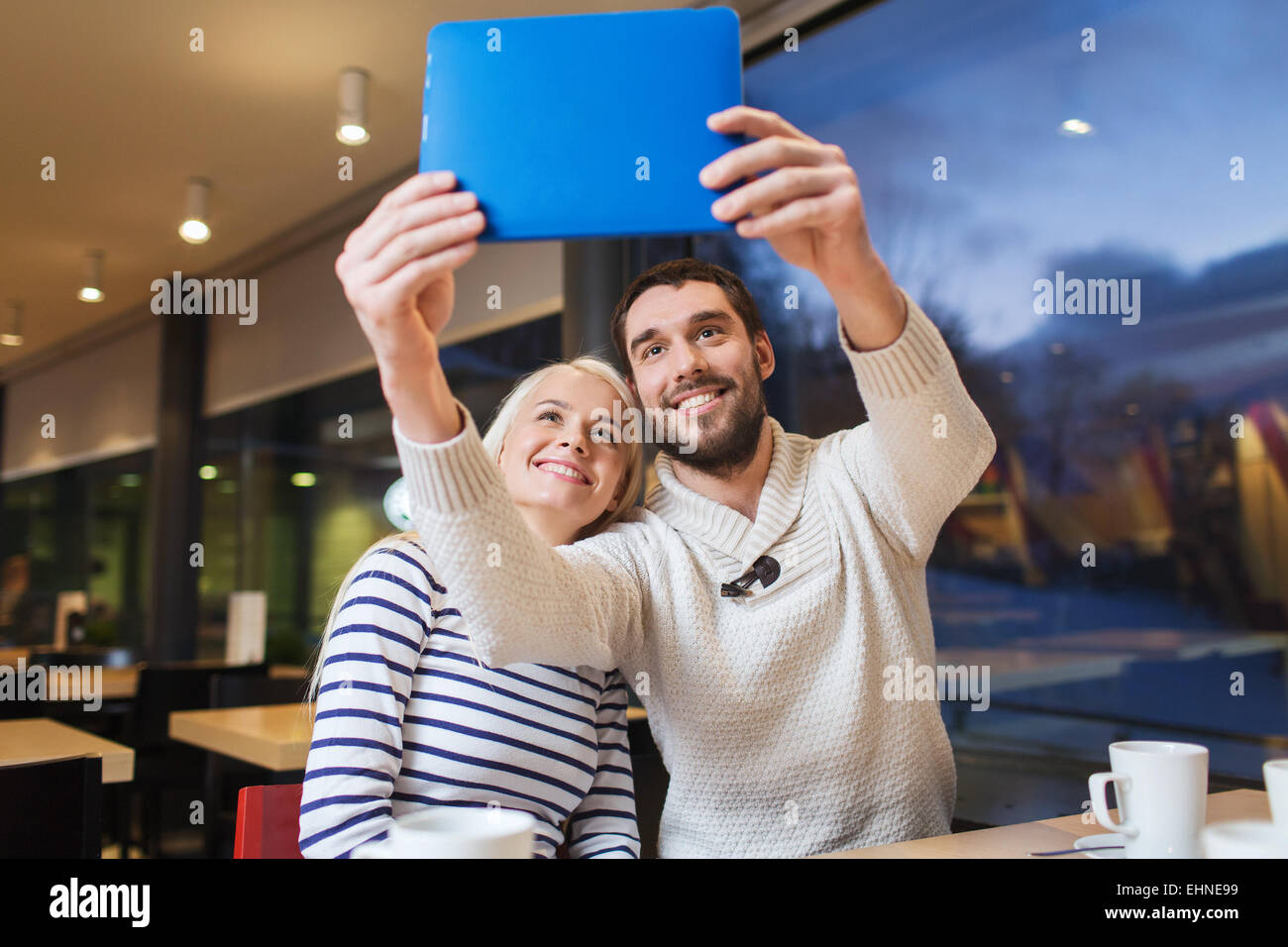 happy couple with tablet pc taking selfie at cafe Stock Photo - Alamy
