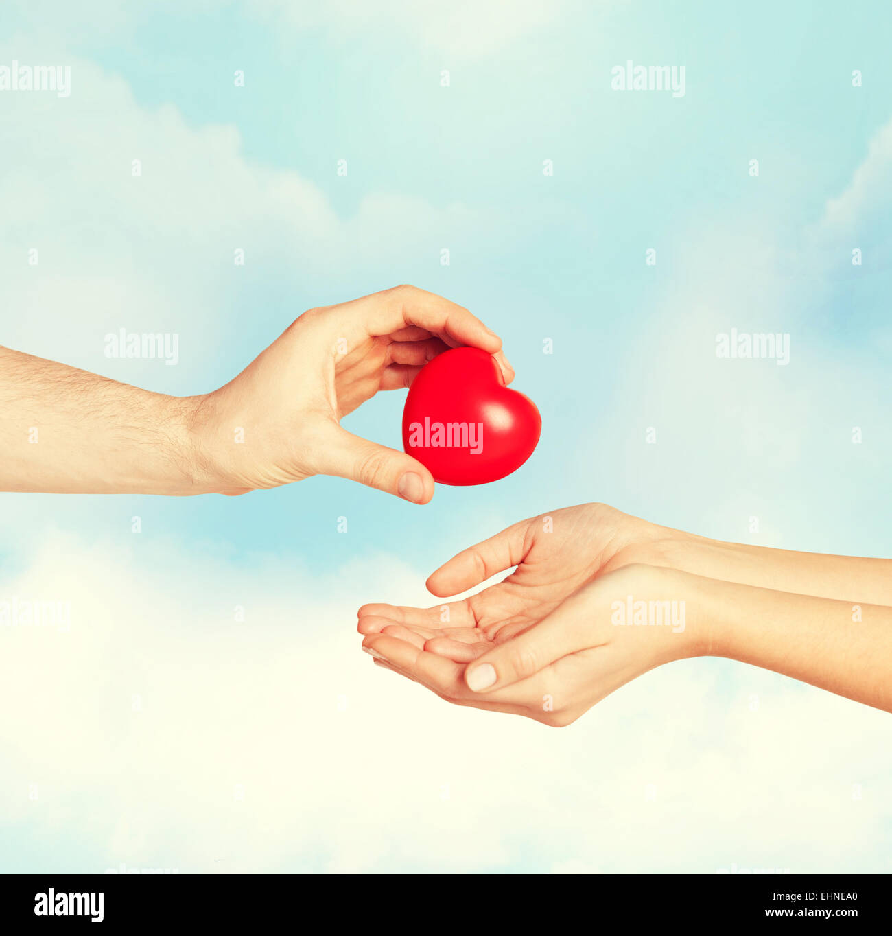 man hand giving red heart to woman Stock Photo - Alamy