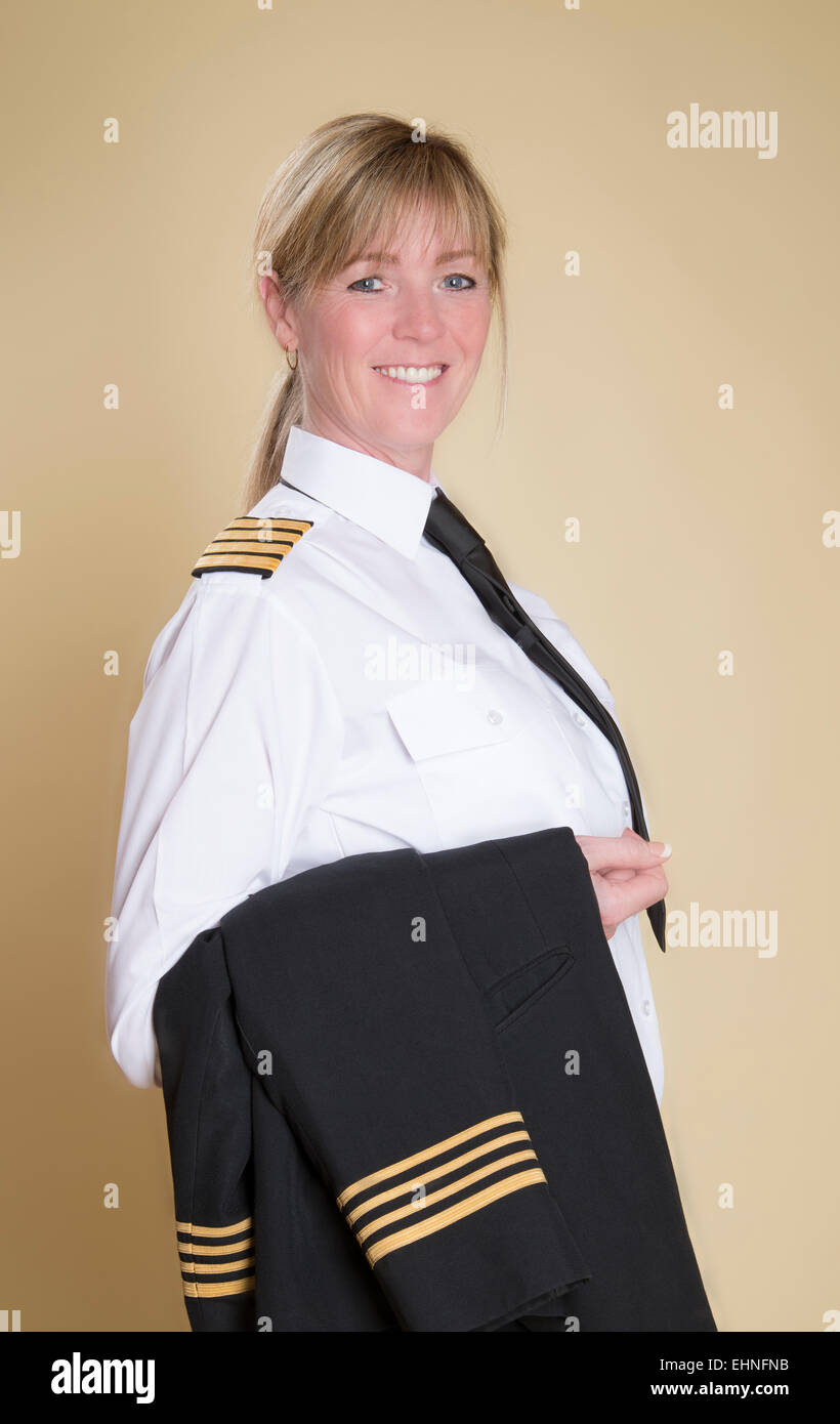 Attractive female airline Captain standing in uniform holding jacket ...