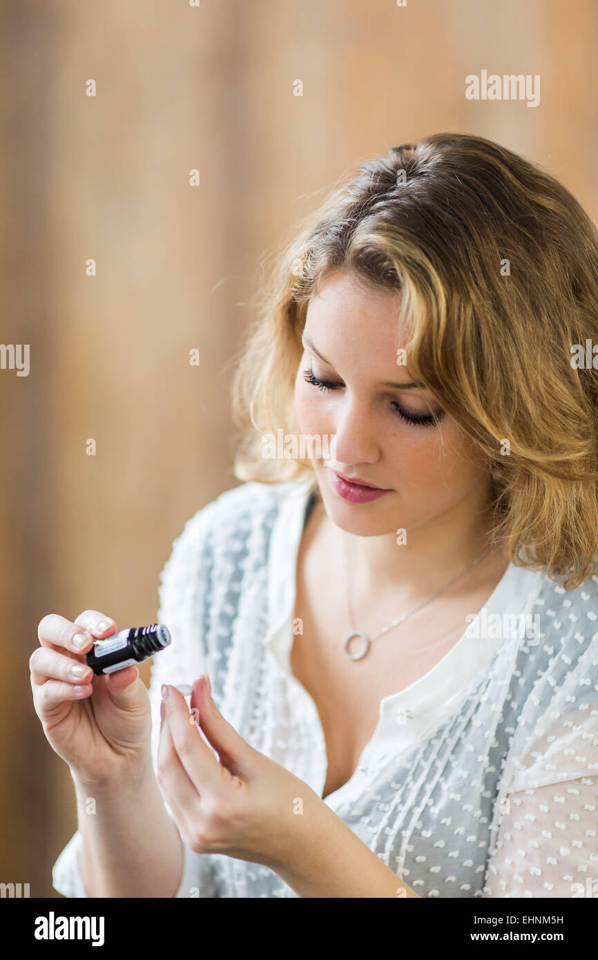 Woman applying essential oil on a neutral pill Stock Photo - Alamy