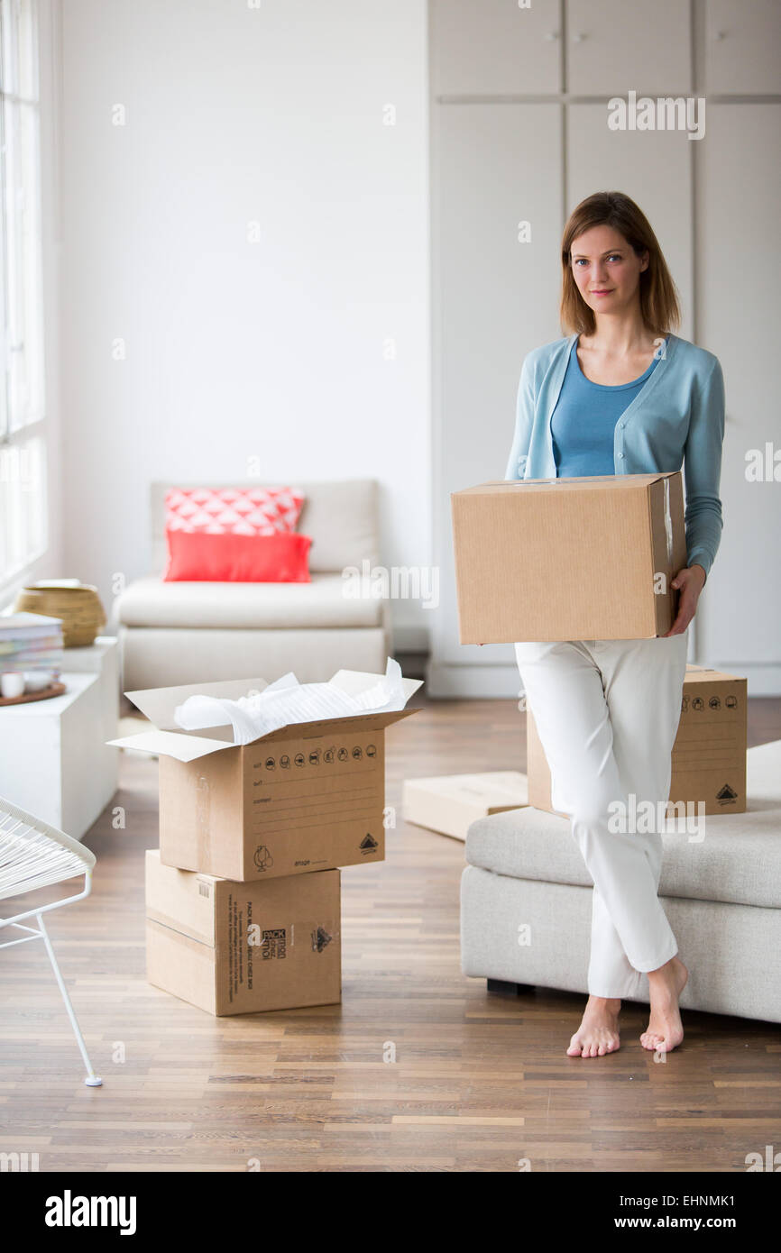 Woman carrying moving boxes in her new home Stock Photo - Alamy