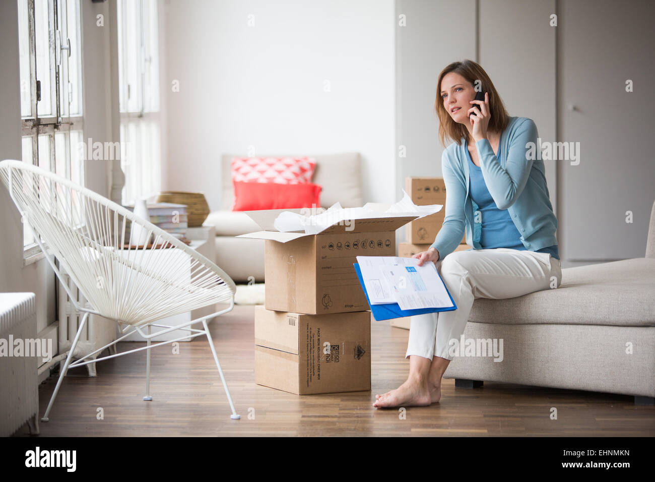 Woman carrying moving boxes in her new home Stock Photo - Alamy