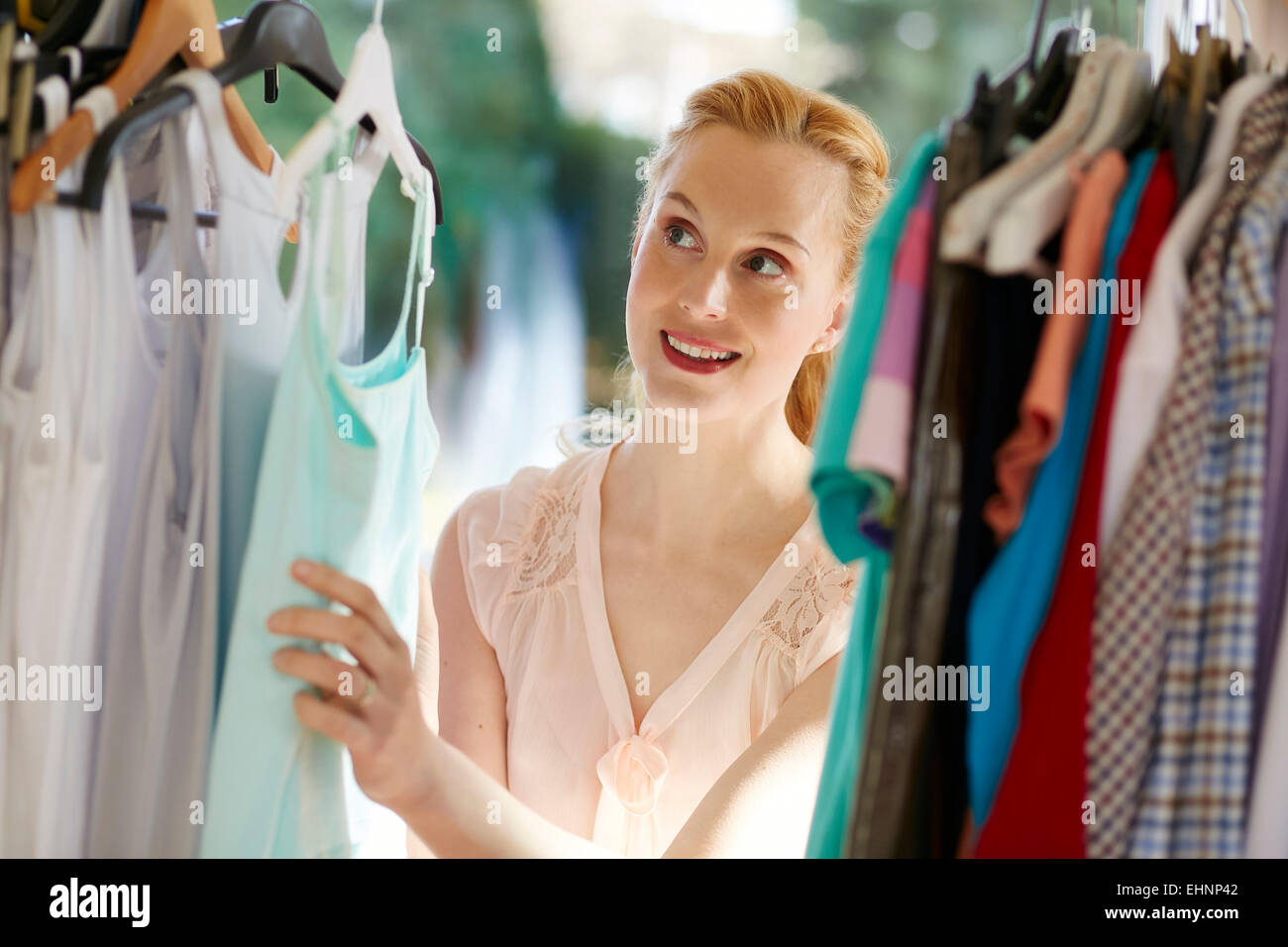 Attractive woman looking through clothes Stock Photo - Alamy