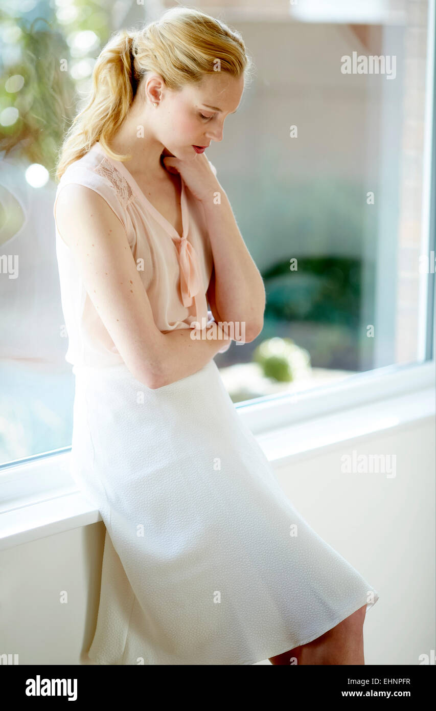 Woman in window thinking Stock Photo - Alamy
