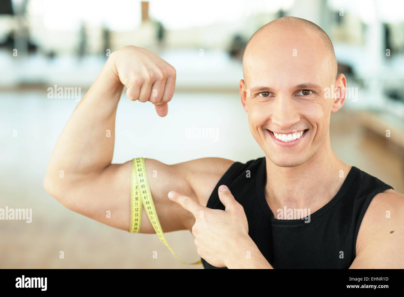 Strong man measuring his arm Stock Photo - Alamy