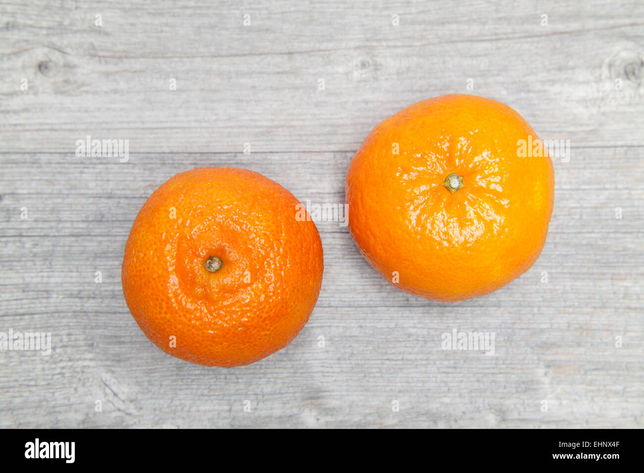 two tangerines on a grey table Stock Photo - Alamy