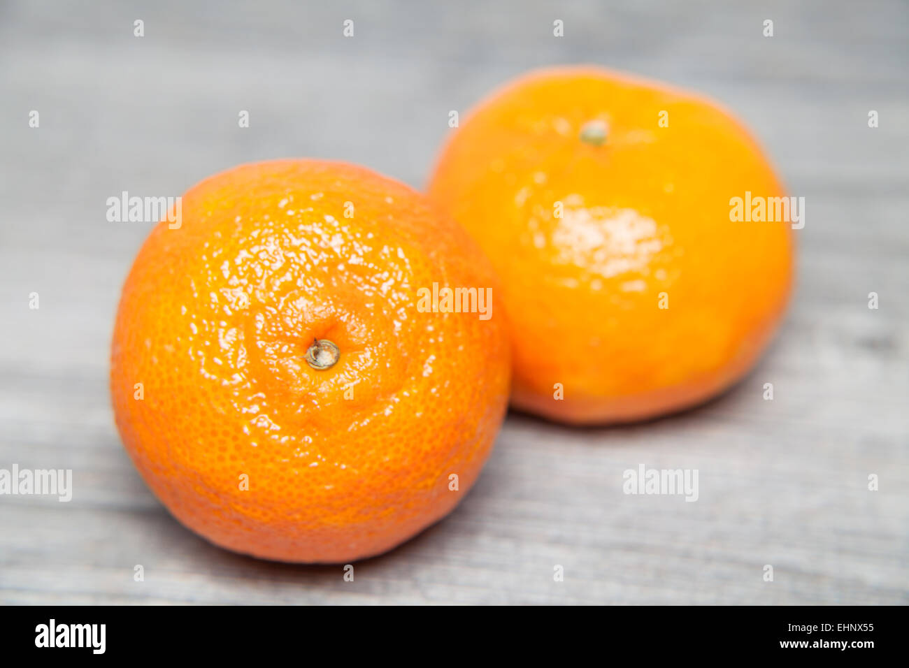 two tangerines on a grey table Stock Photo - Alamy