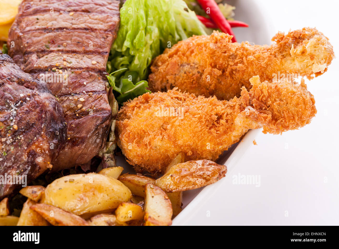 Wholesome platter of mixed meats including grilled steak, crispy ...