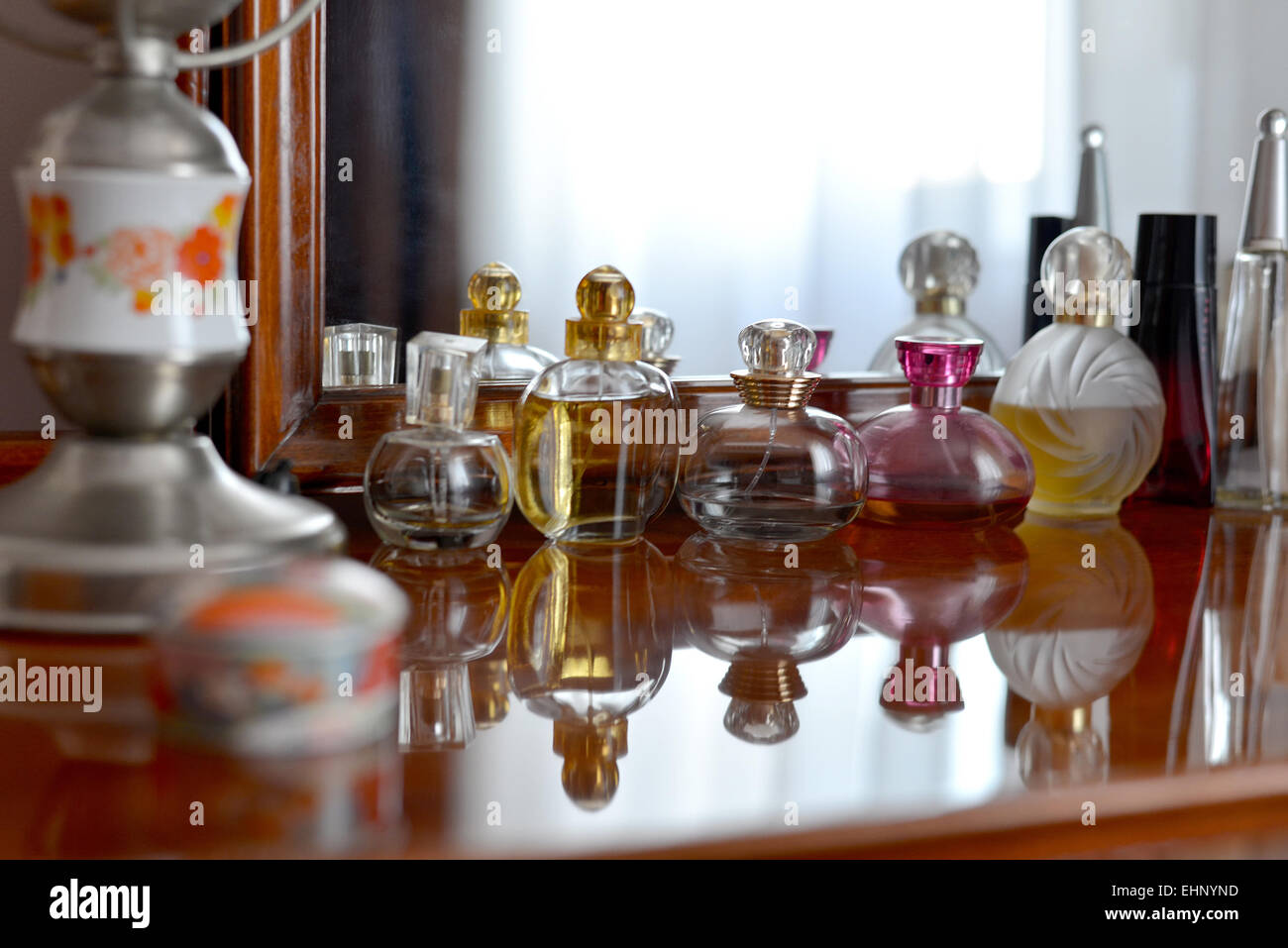 More perfume bottles set on a cabinet in front of the mirror Stock ...