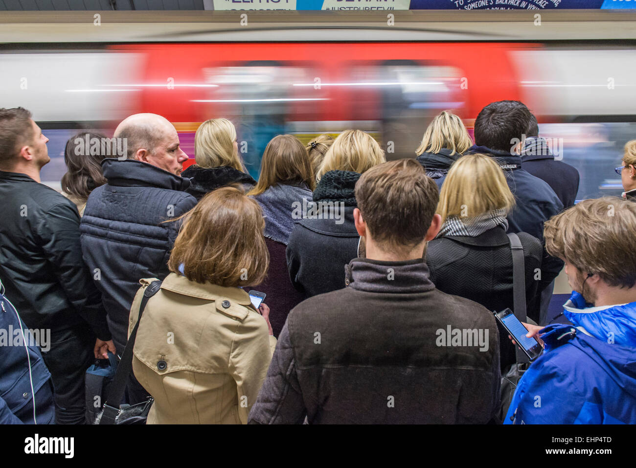 London, UK. 16th March, 2015. Passengers await packed Northern Line ...