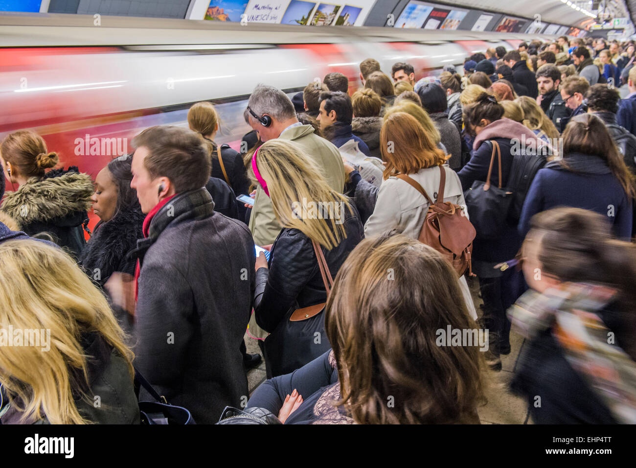 London, UK. 16th March, 2015. Passengers await packed Northern Line ...