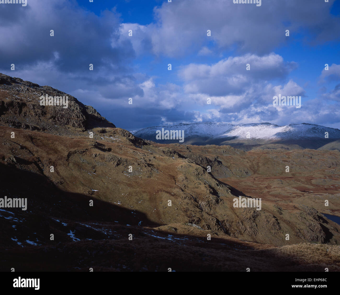 Storm & shower clouds passing over snow capped summit of Helvellyn from ...
