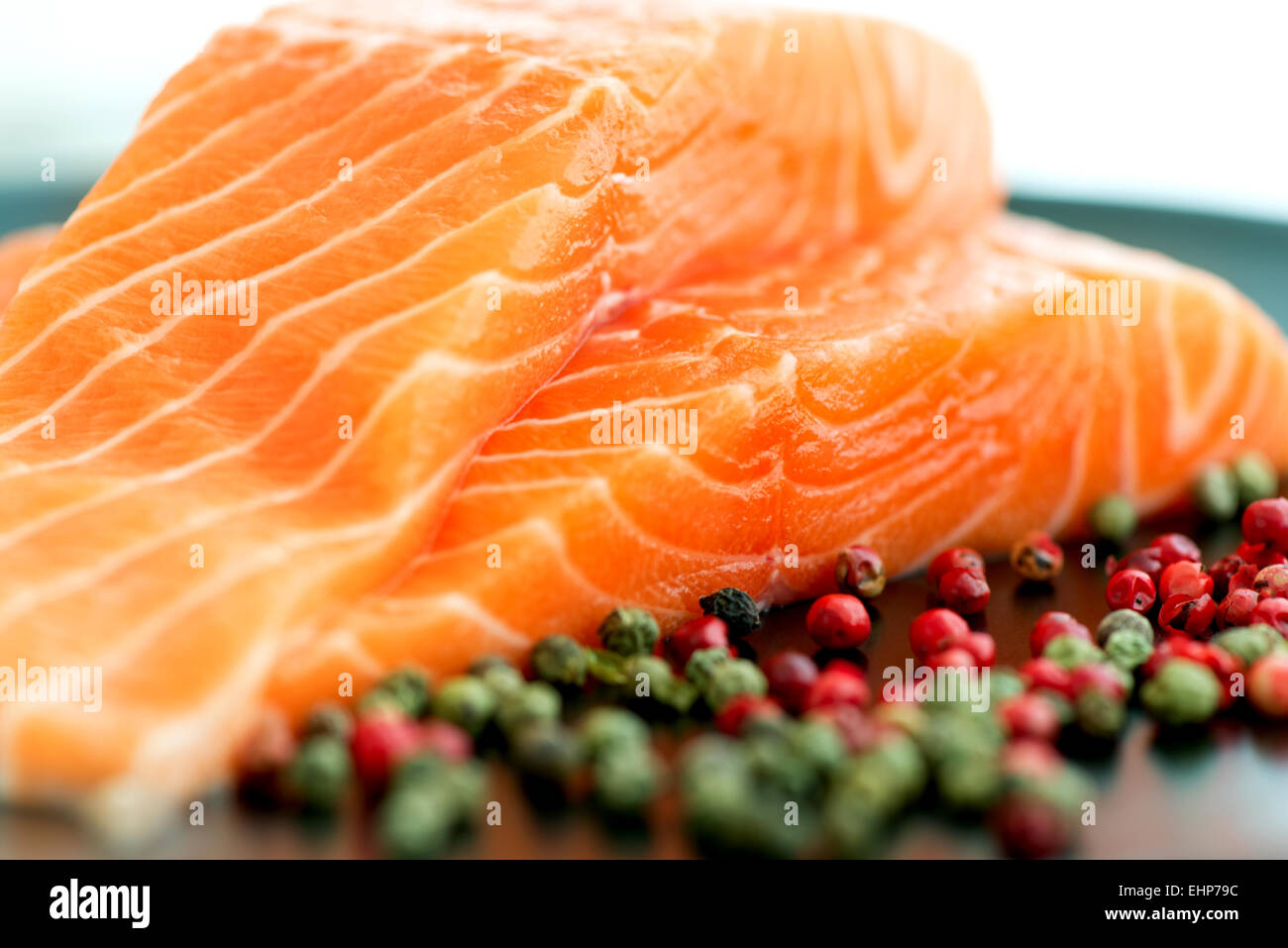 Raw salmon ready to cook close up on black surface Stock Photo - Alamy