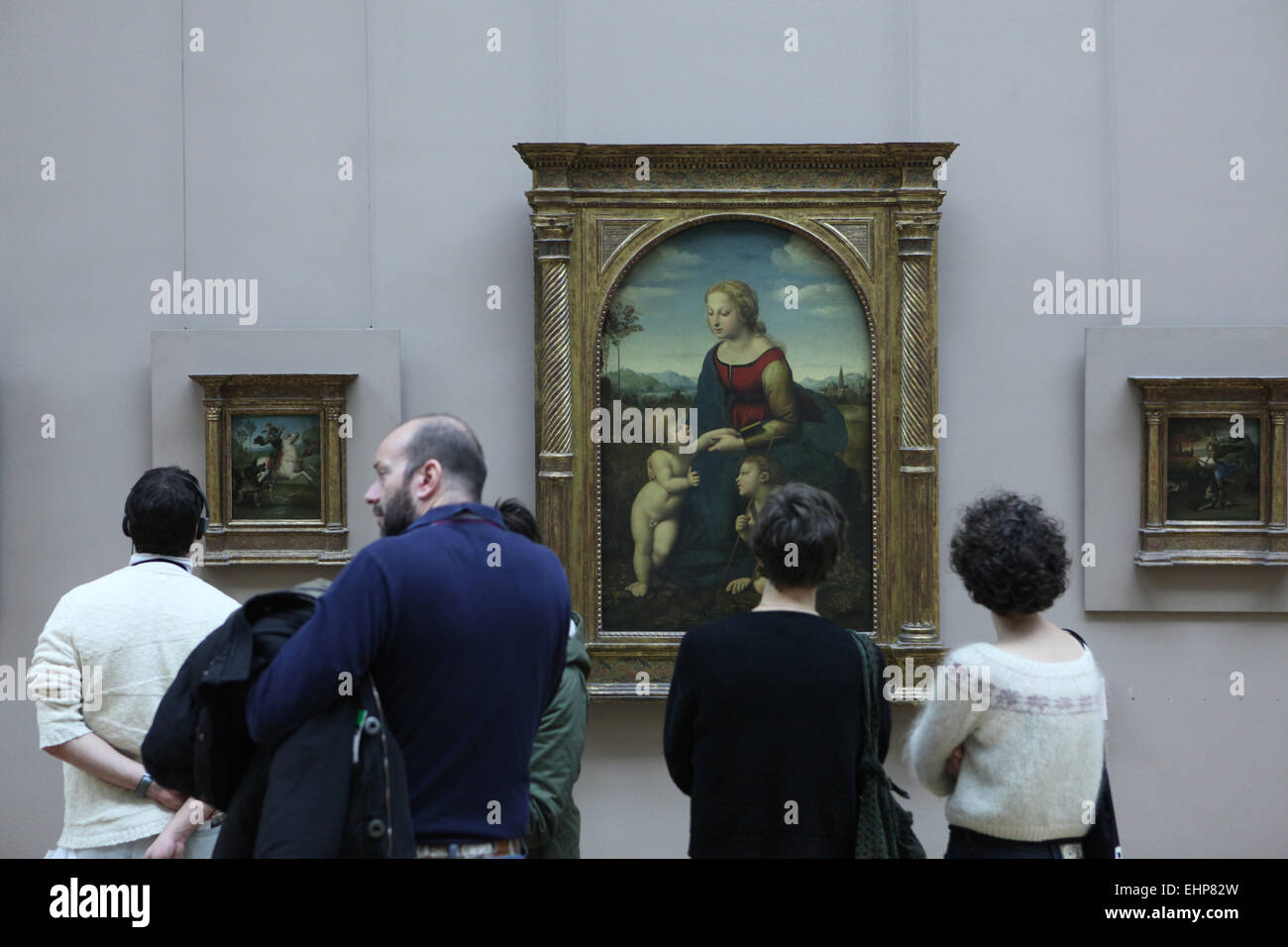 Visitors in front of the painting 'La Belle Jardiniere' (1507) by Italian painter Raphael ...